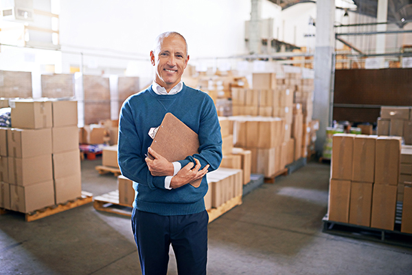 Man holding paperwork in warehouse | Nacha